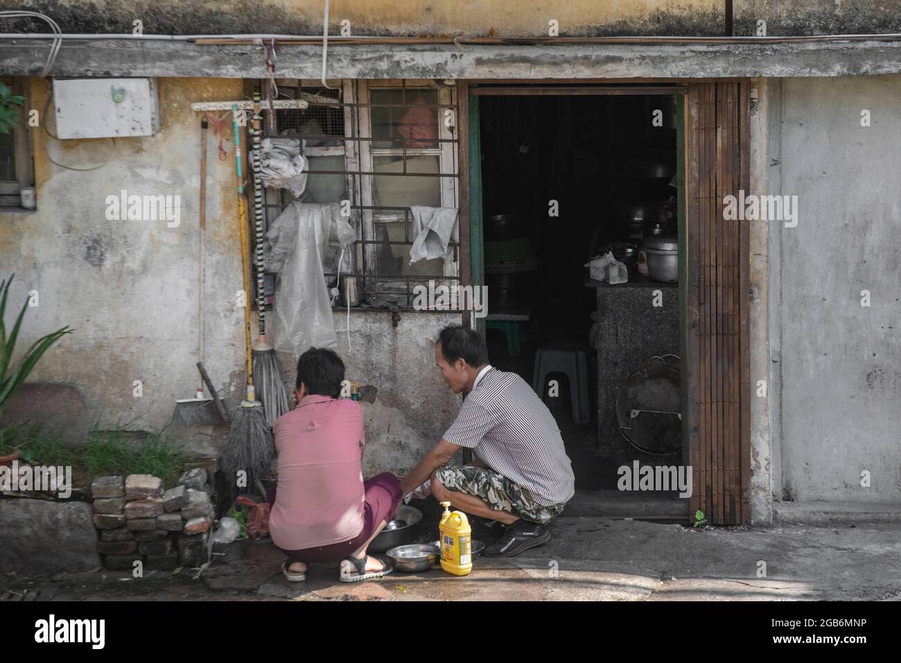 A couple wash up their crockery, chopsticks and cutlery inside the ...