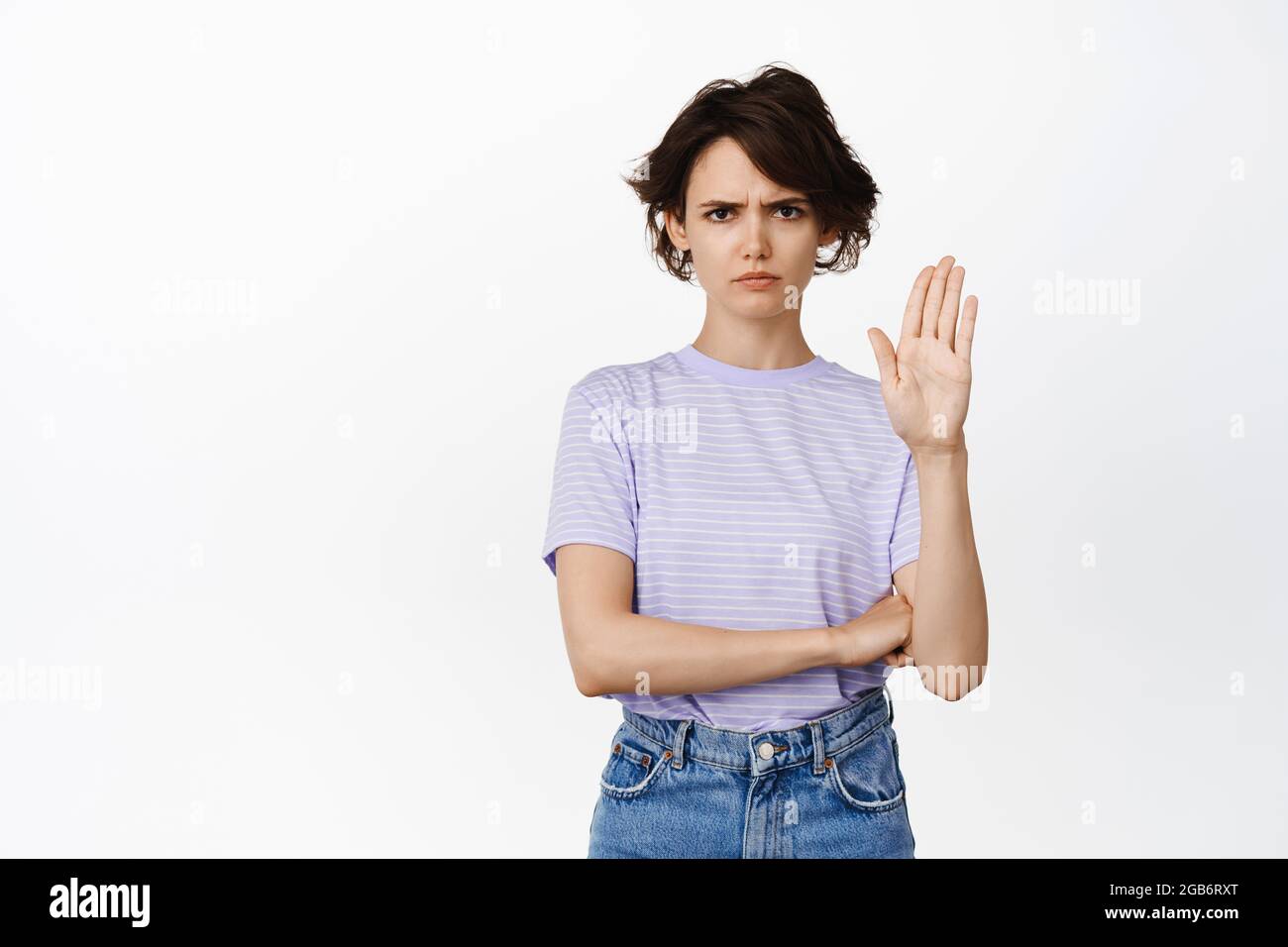Stop, I said no. Serious and confident woman raise one hand to block ...