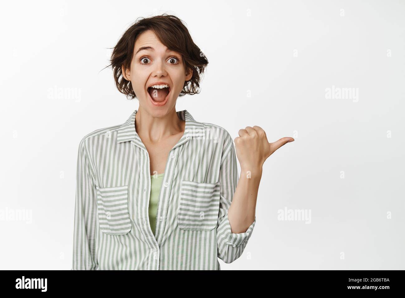Pointing of happy girl pointing finger right, smiling amazed, showing ...