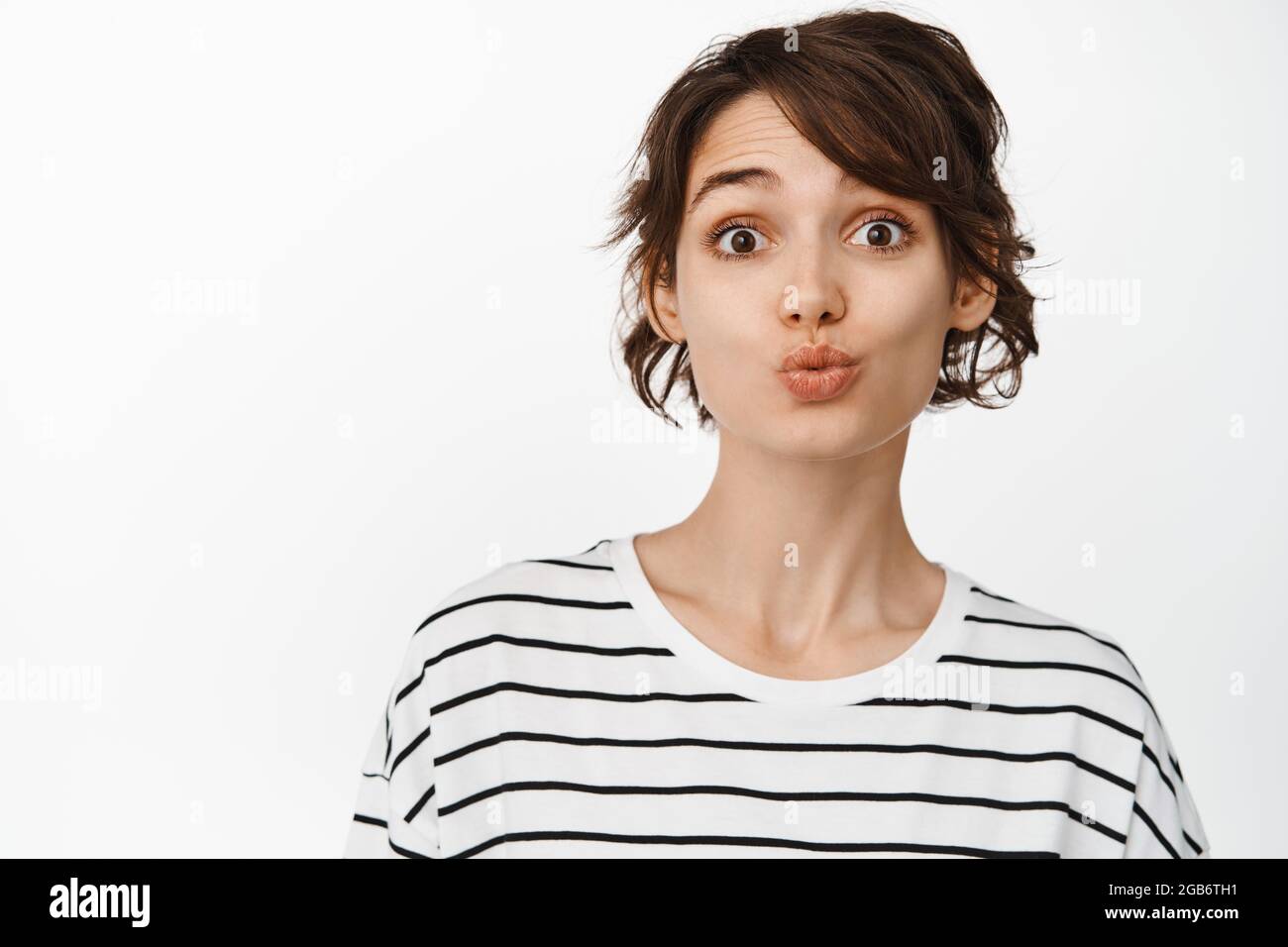 Close up of silly and cute brunette girl pucker lips, funny kissing ...