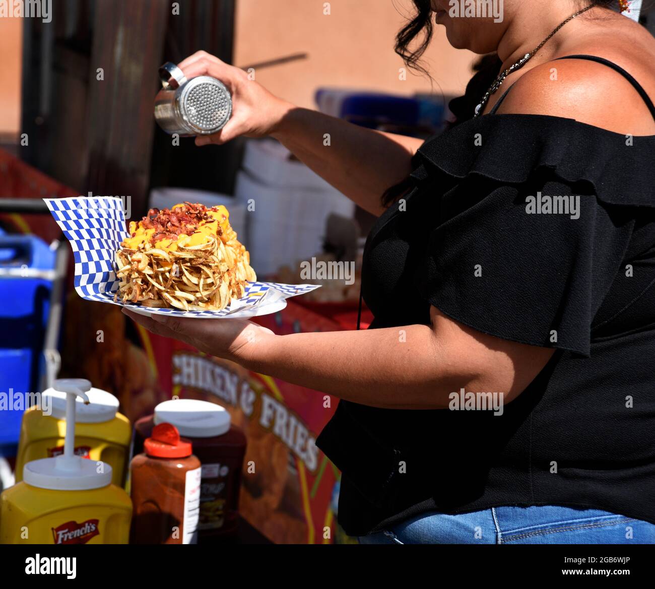 A woman purchases a fast food lunch made up from french fries, cheese ...