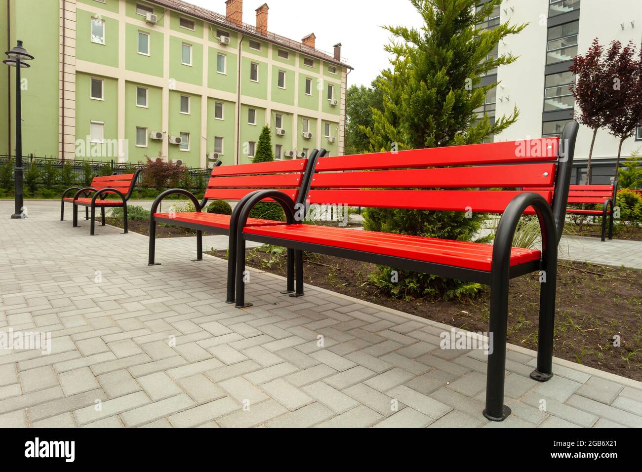 beautiful red wooden bench in the courtyard of a new residential ...