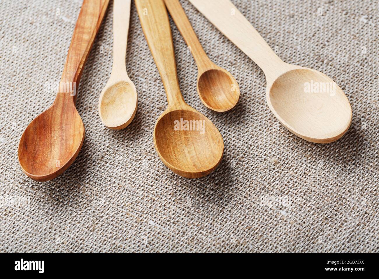 Wooden spoons made of natural wood on burlap fabric as a craft. Natural ...