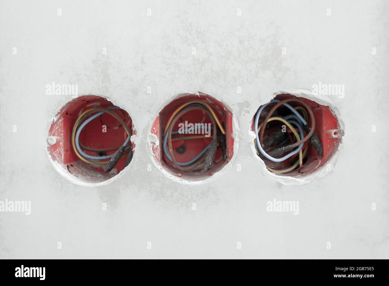 sockets with wires on a putty wall Stock Photo - Alamy