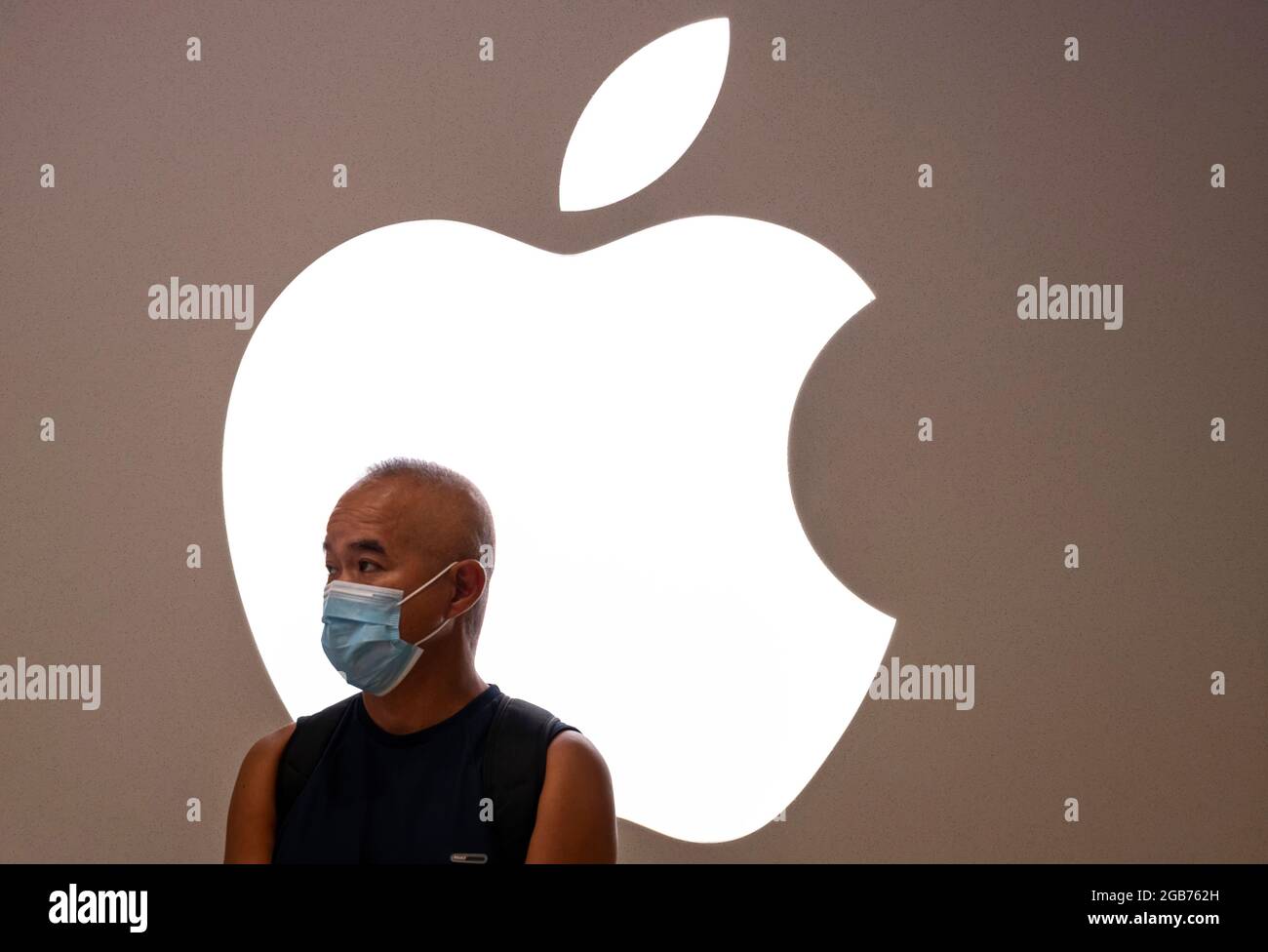 A man wearing a face mask is seen standing in front of the American ...