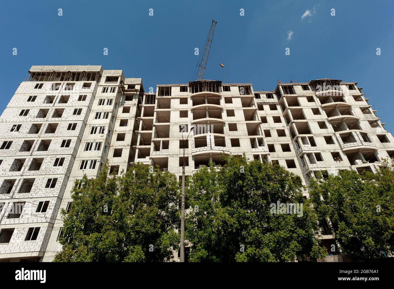 Multi-storey residential building under construction and crane on a ...