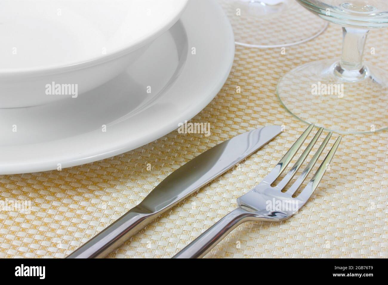 Table setting with fork, knife, plates, and napkin Stock Photo - Alamy
