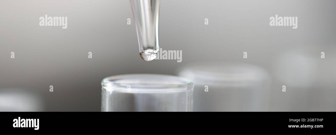 Clear liquid drips from pipette into test tube Stock Photo - Alamy