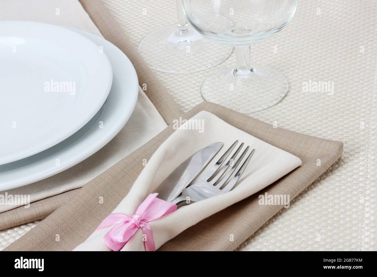 Table setting with fork, knife, plates, and napkin Stock Photo - Alamy