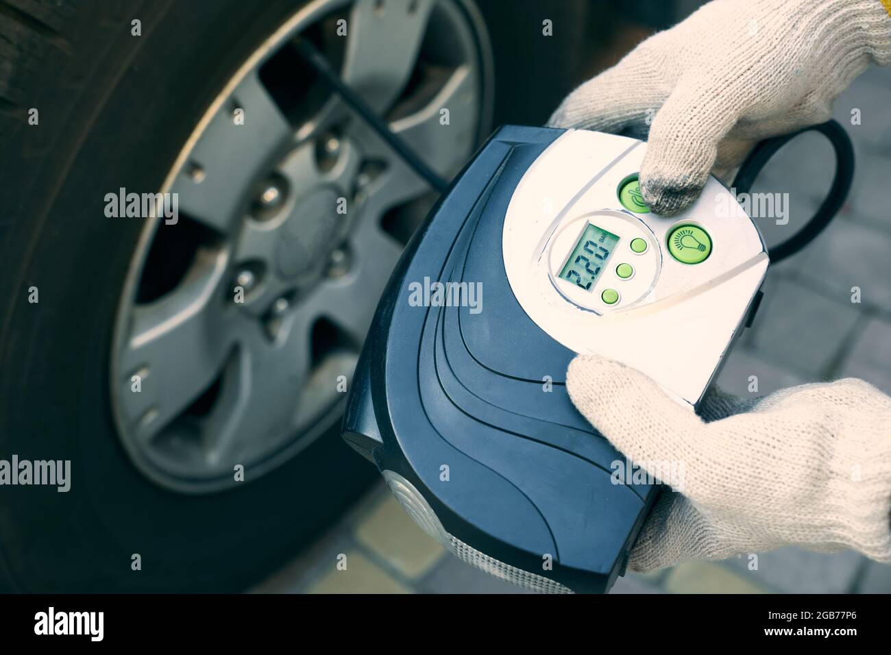 Inflating a car wheel with air using a compressor. Closeup photo ...