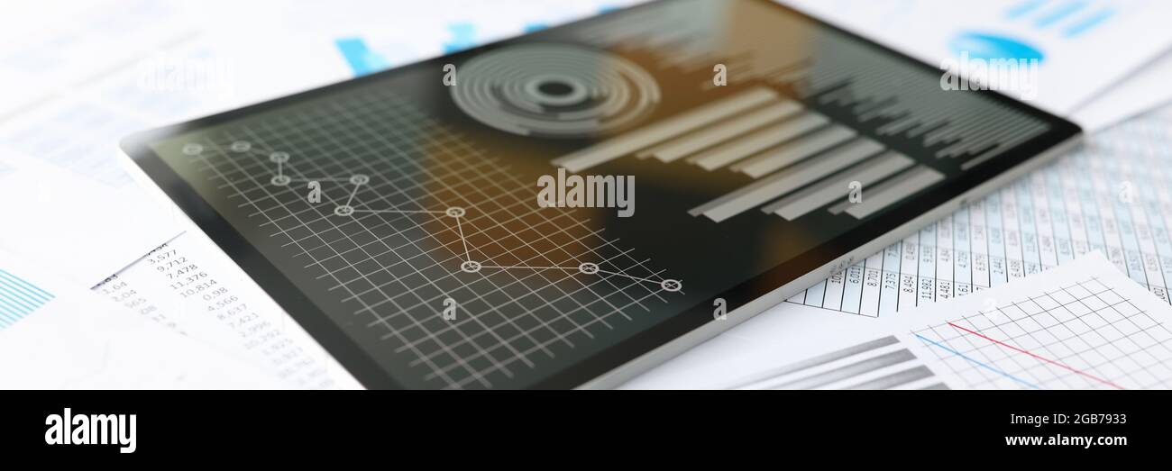 Tablet with business indicators in charts is on desktop Stock Photo - Alamy