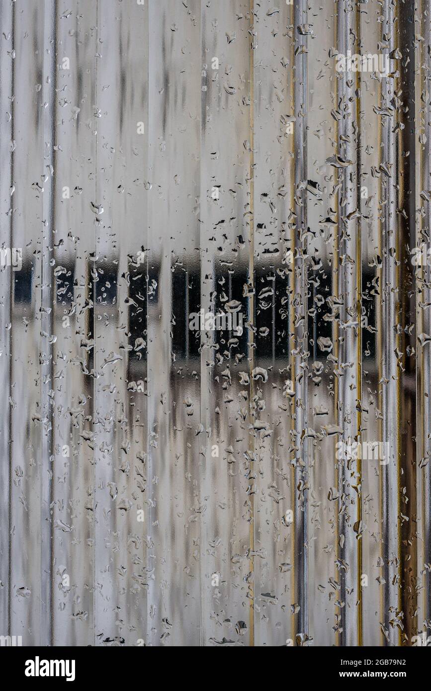 Wet glass texture with rain water drops. Very cold day in the city ...