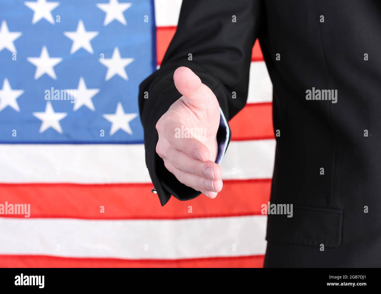 Businessman giving his hand for a handshake on American flag background ...