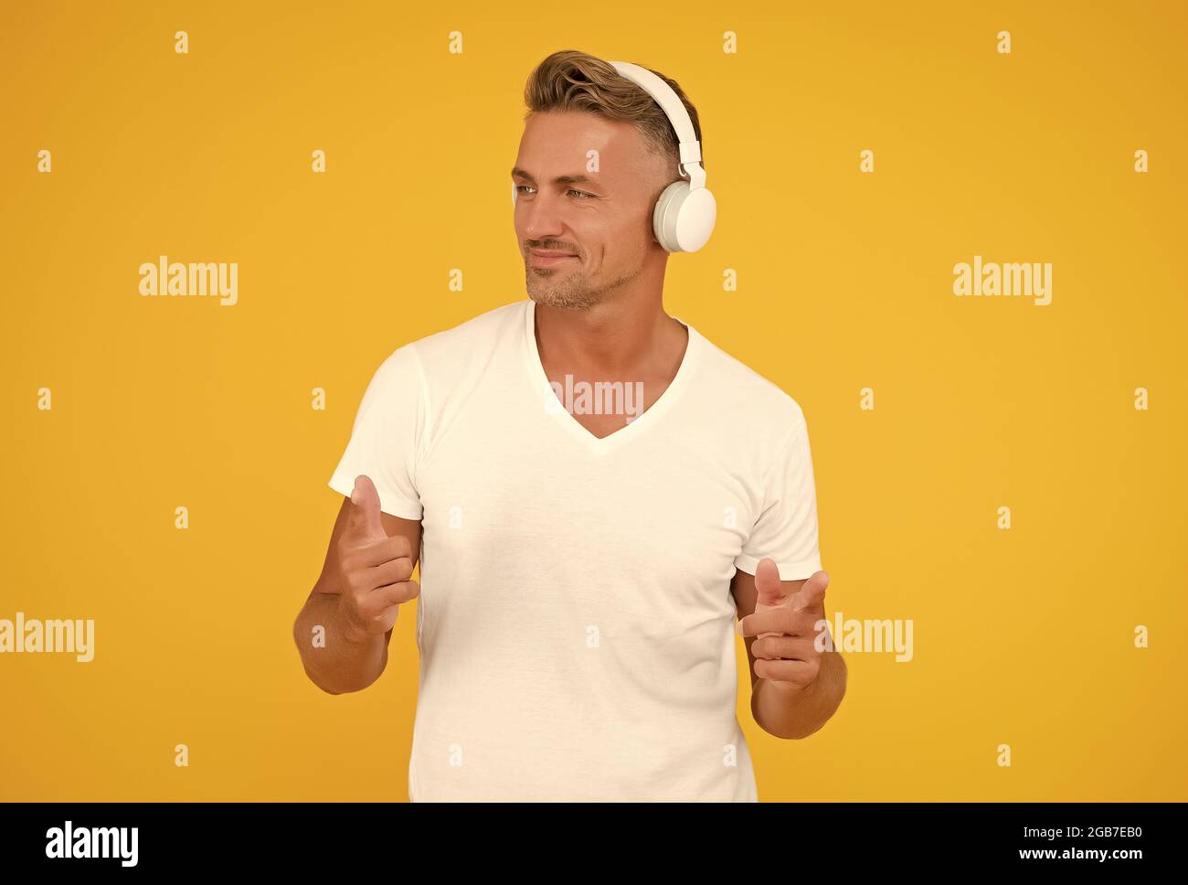 Happy Middle Aged Man Listen To Music In Modern Headphones Pointing