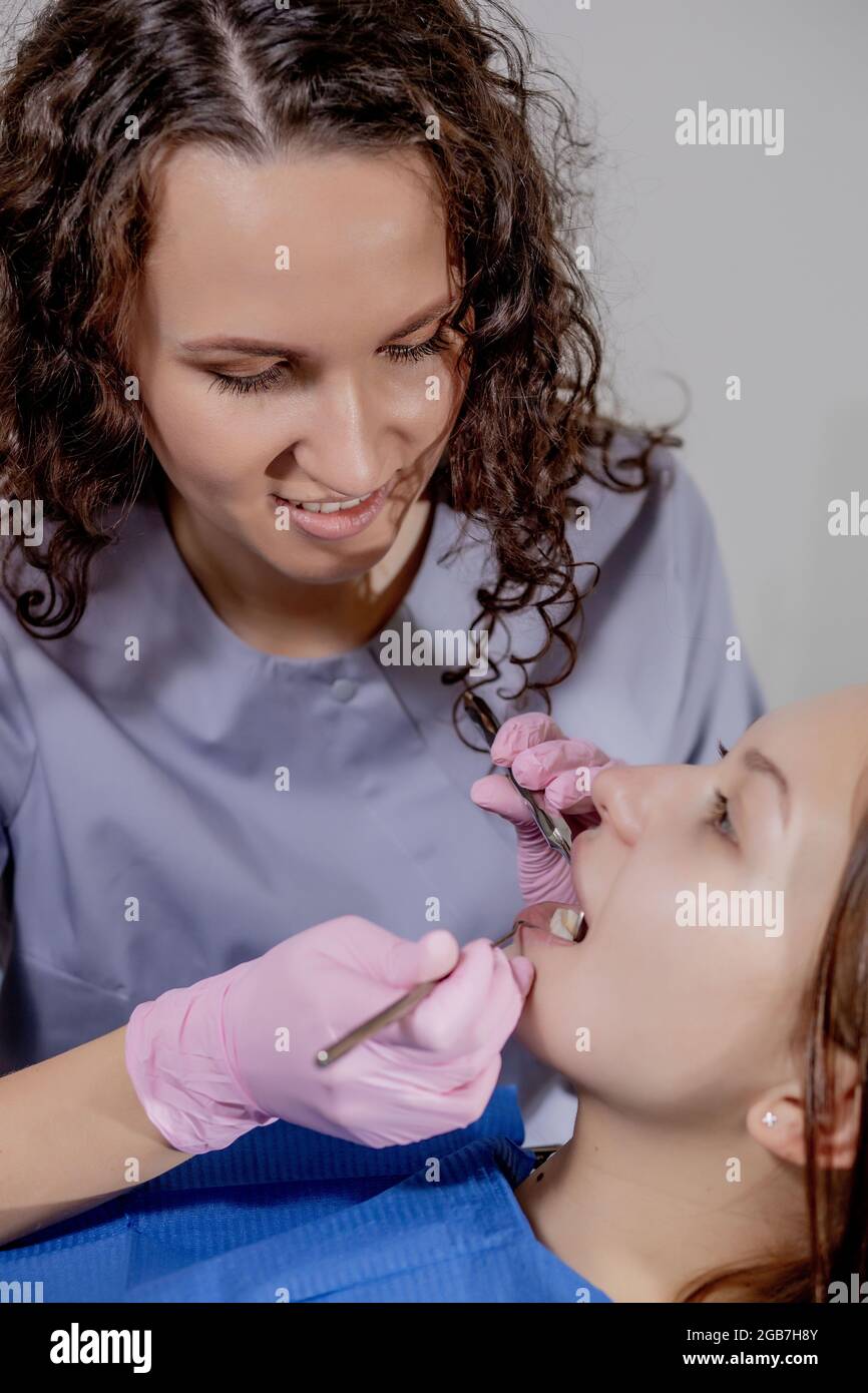 Close-up of female with open mouth during oral checkup at the dentist ...