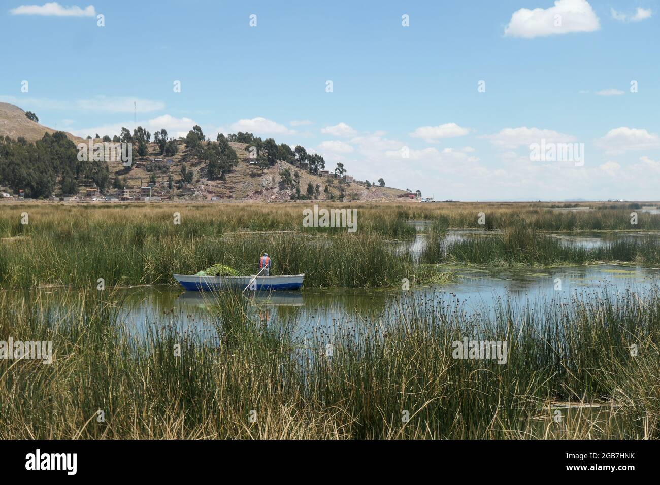 boat on lake Titicaca Peru water edge mountain reeds reed sky ...