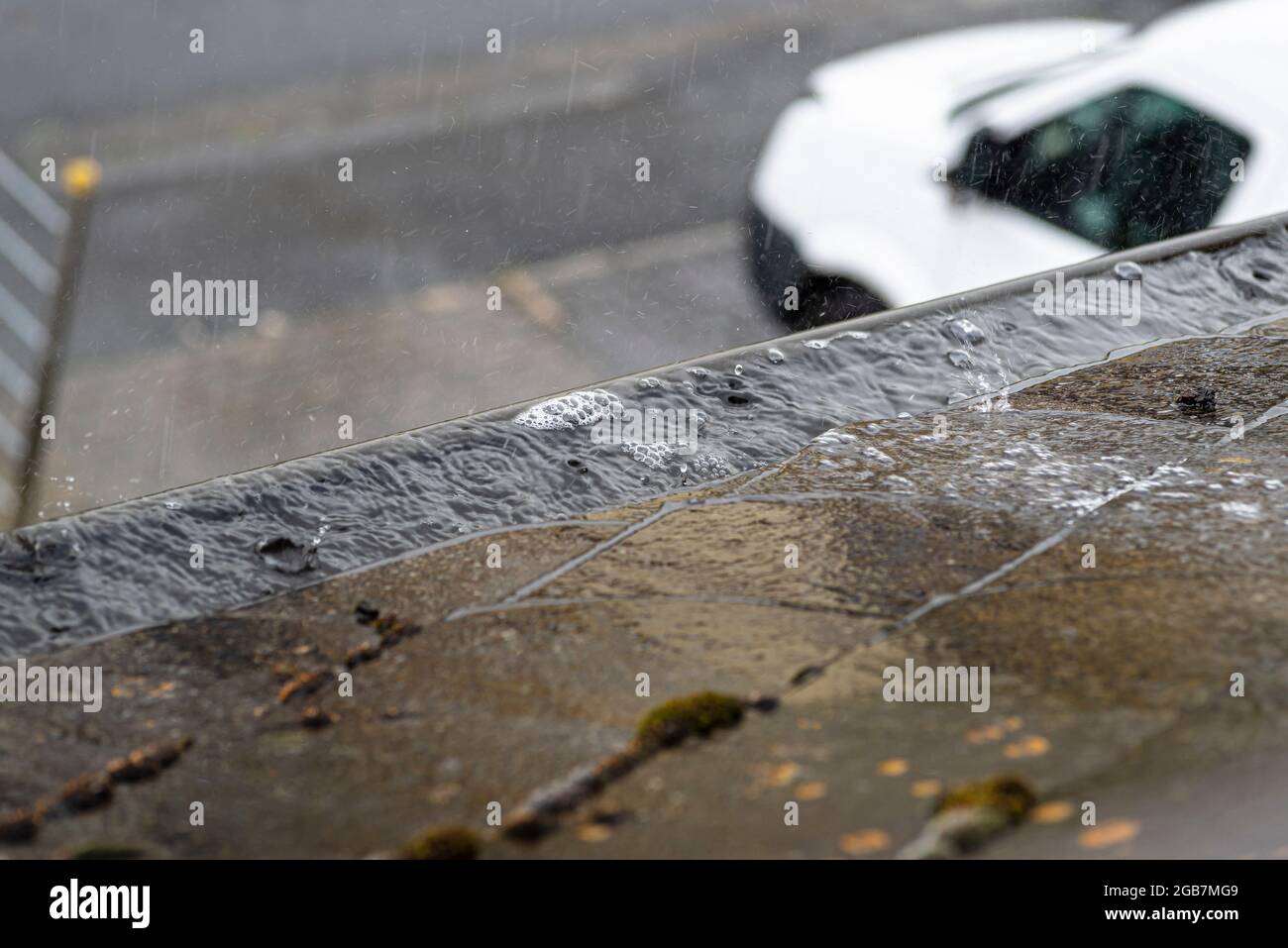 Clogged gutter filled with water that overflows in rainy weather Stock ...
