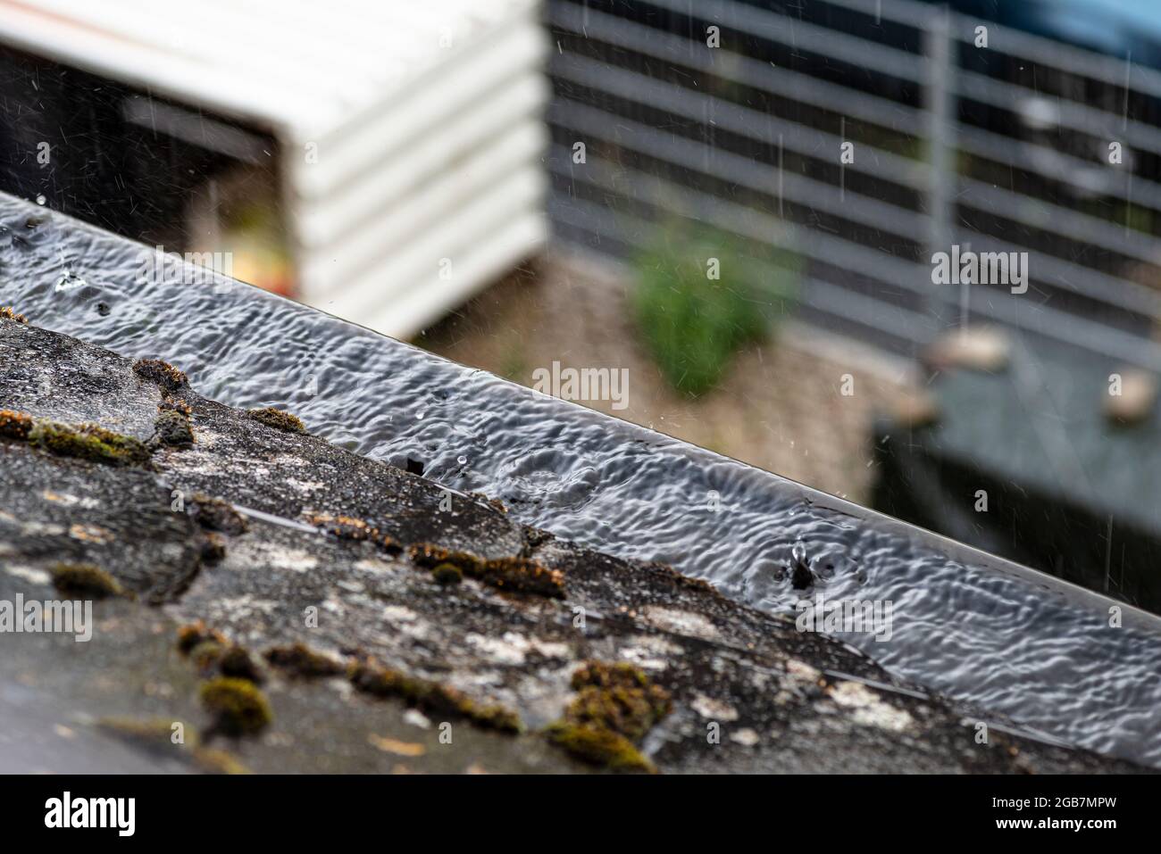 Clogged gutter filled with water that overflows in rainy weather Stock ...