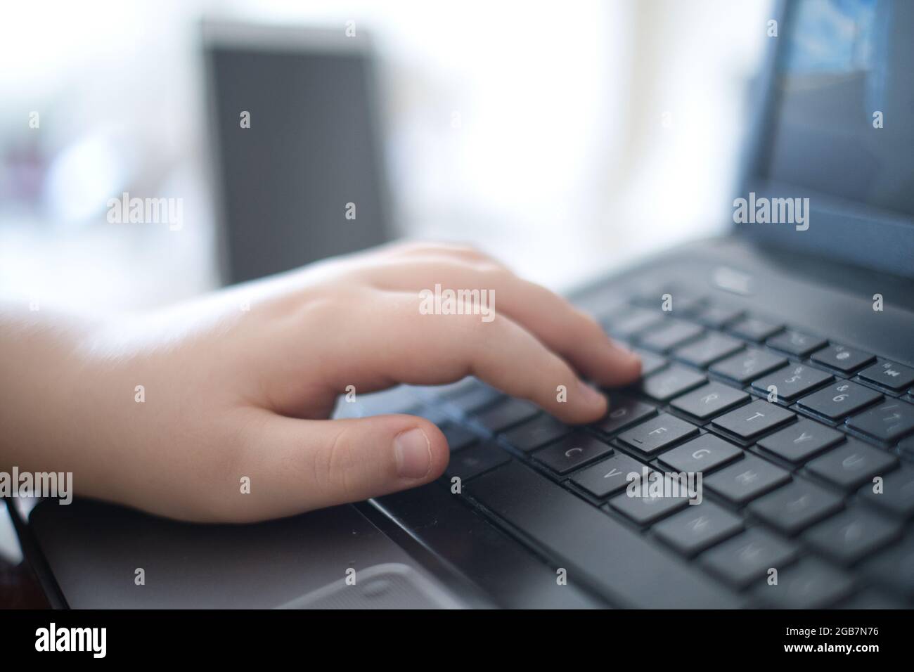 Concept idea of a child with hands on the keyboard pressing the keys of ...