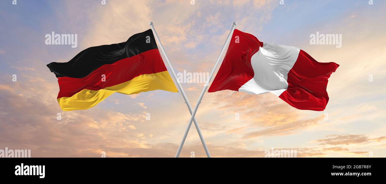 flags of Germany and Peru waving in the wind on flagpoles against sky ...