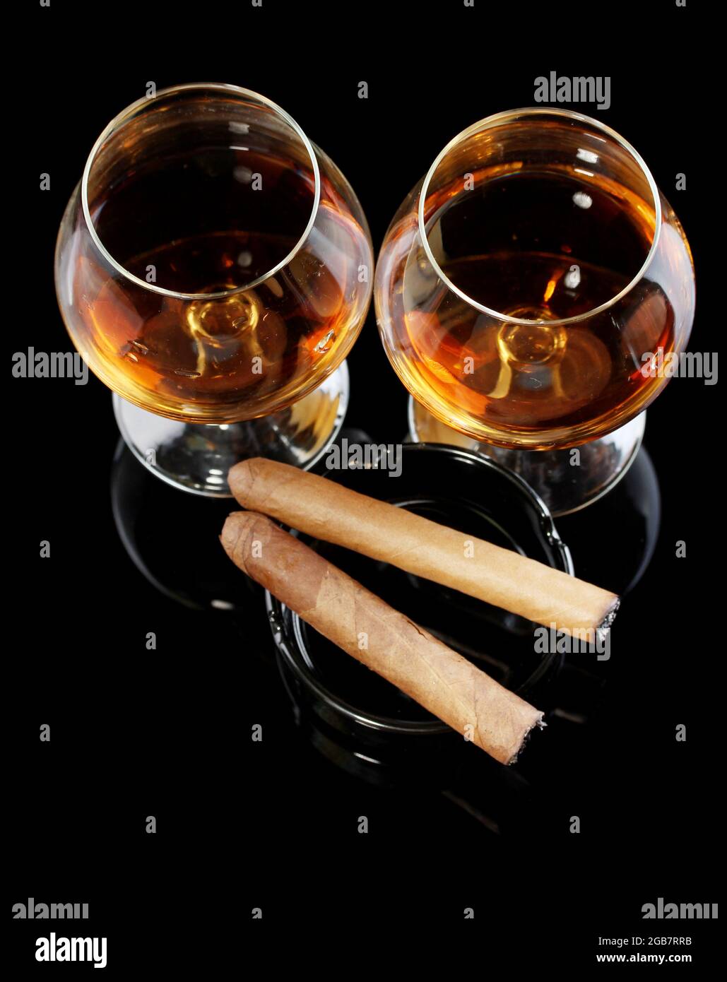 two glasses of brandy and cigars on black background Stock Photo - Alamy