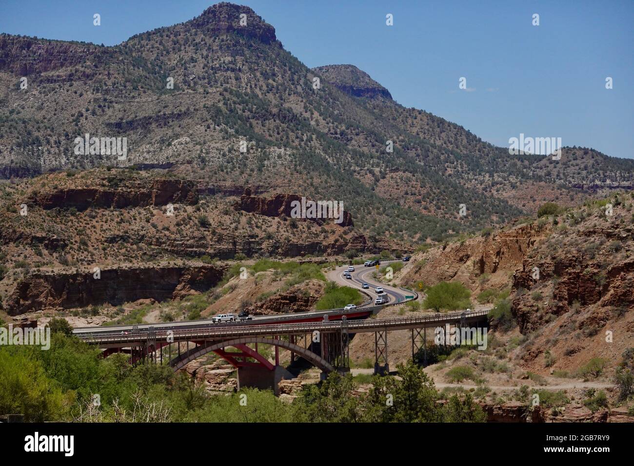 A road curves the the rough mountain desert terrain of the American ...