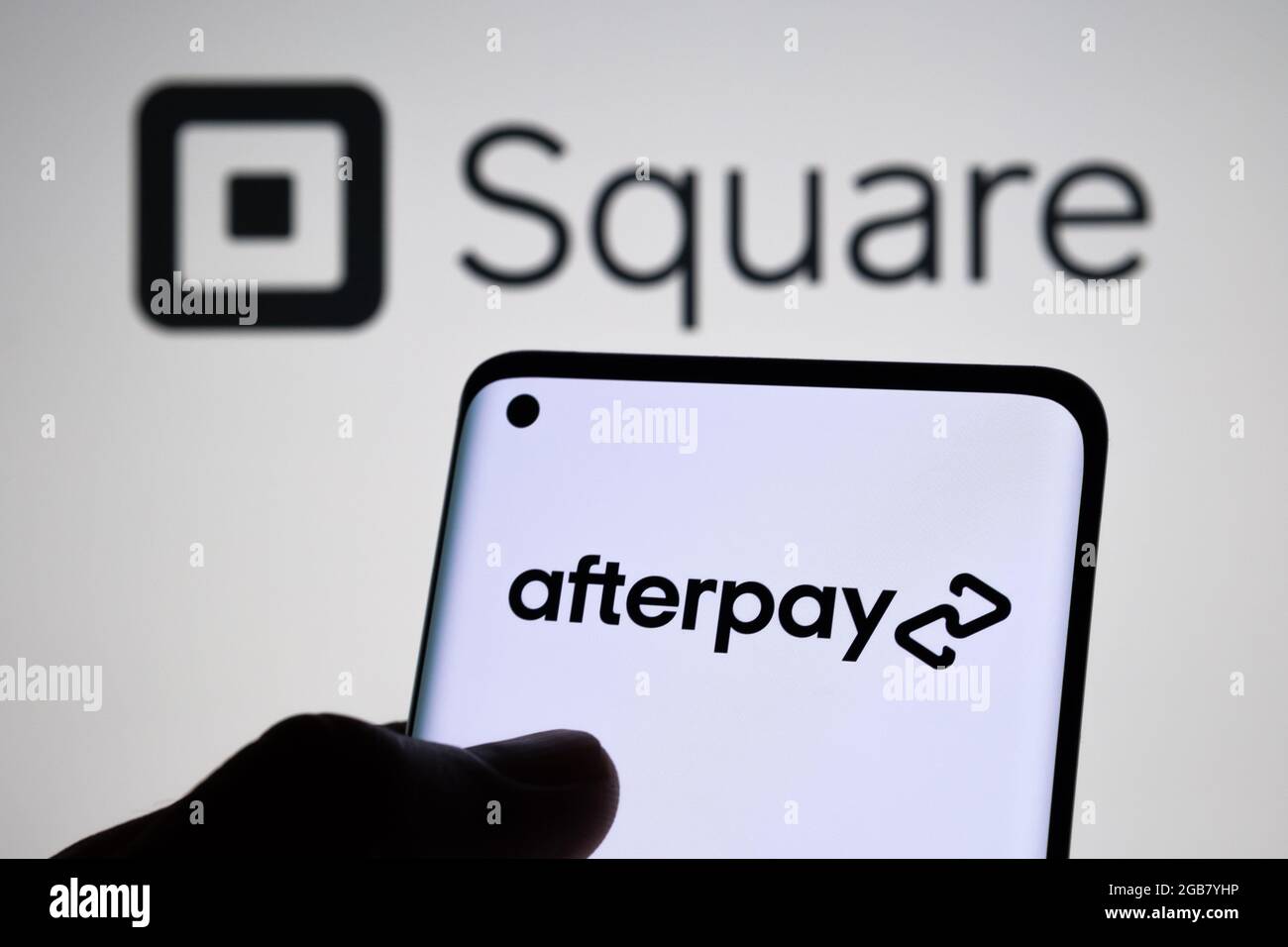 Afterpay company logo seen on smartphone and Square logo on blurred ...