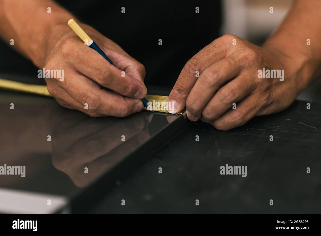 Man marking a surface using a meter in a workshop Stock Photo - Alamy