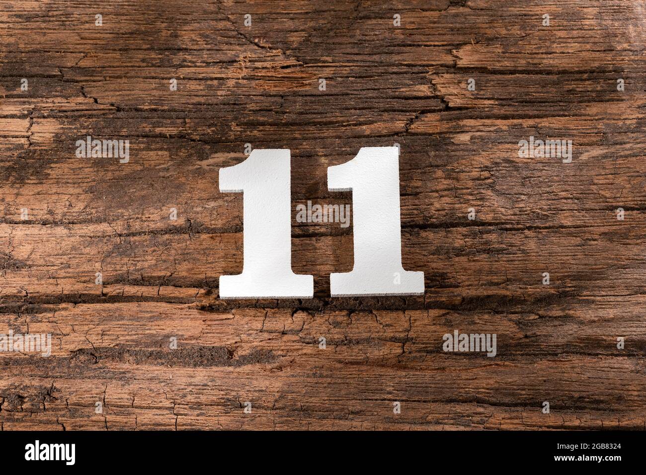 number eleven - White Piece on Rustic Wood Background Stock Photo - Alamy