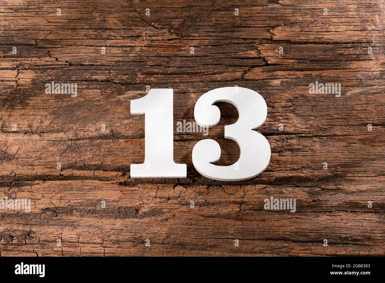 Number thirteen - White Piece on Rustic Wood Background Stock Photo - Alamy