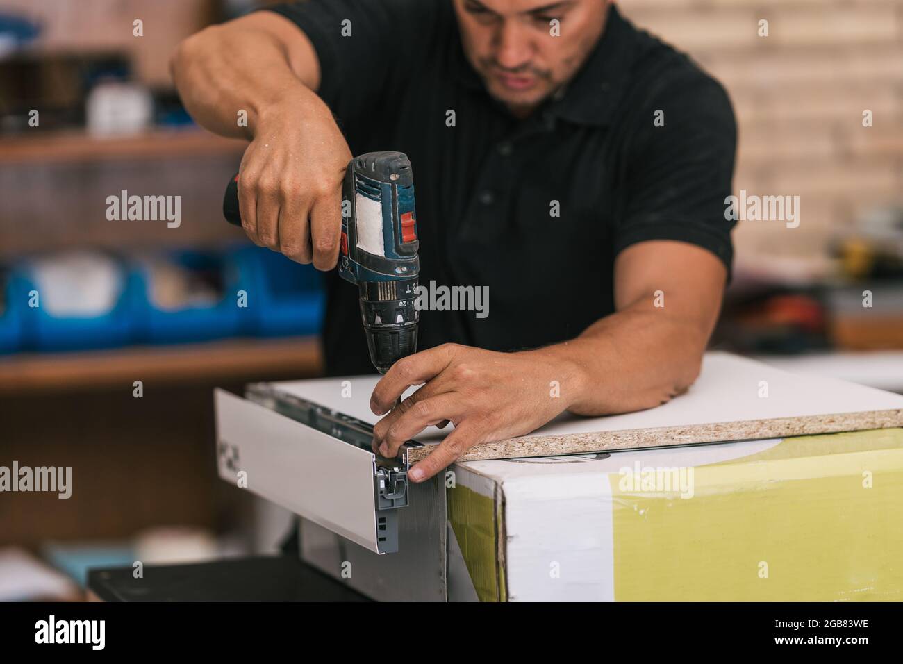 Drill being used by an man to make furniture in a workshop Stock Photo ...