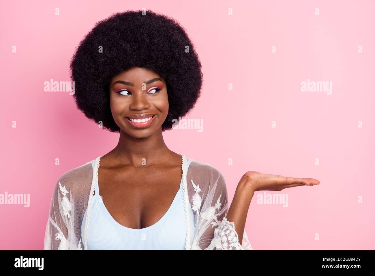 Photo portrait curly woman keeping empty space on palm curious isolated ...