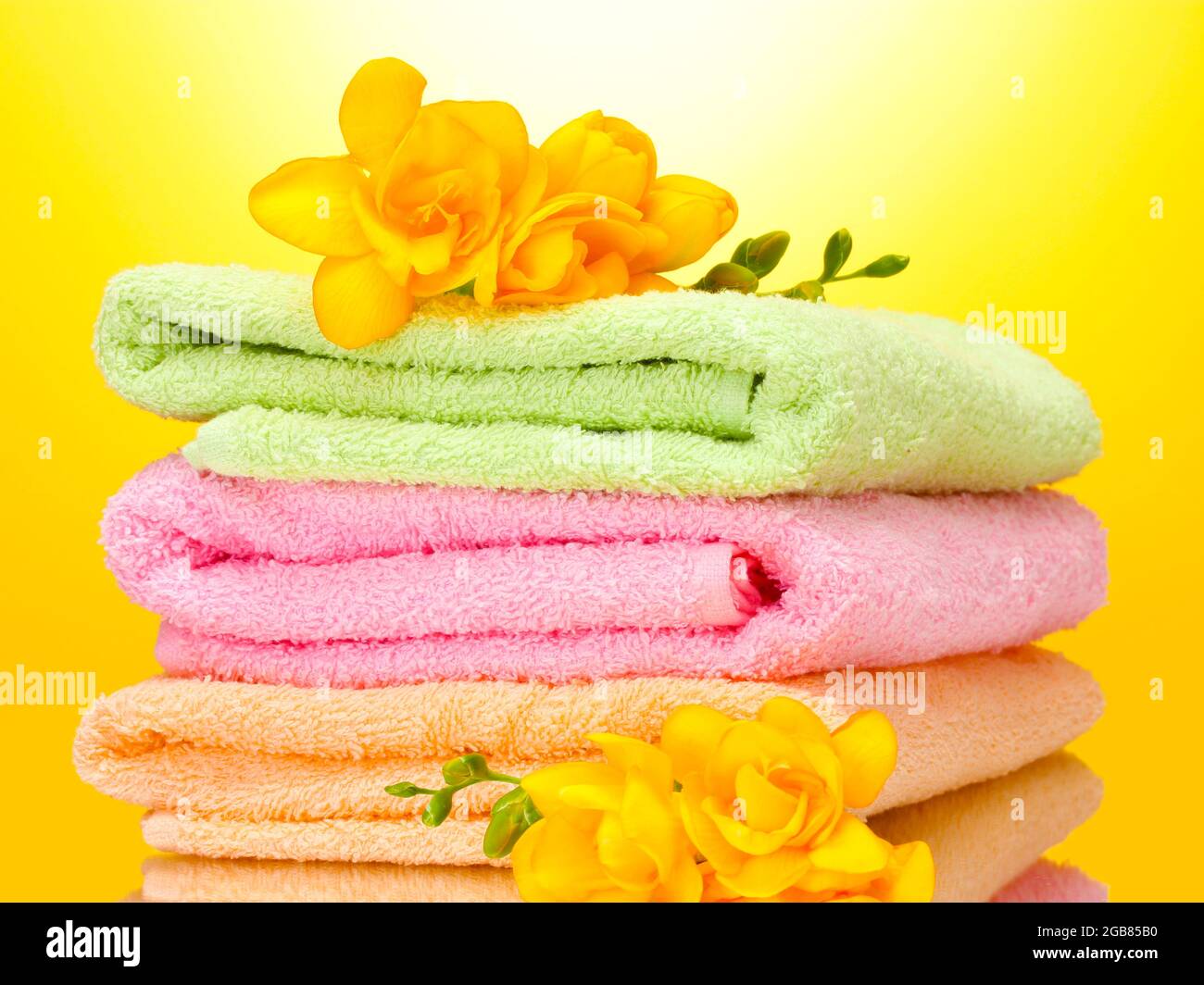 colorful towels and flowers on yellow background Stock Photo - Alamy