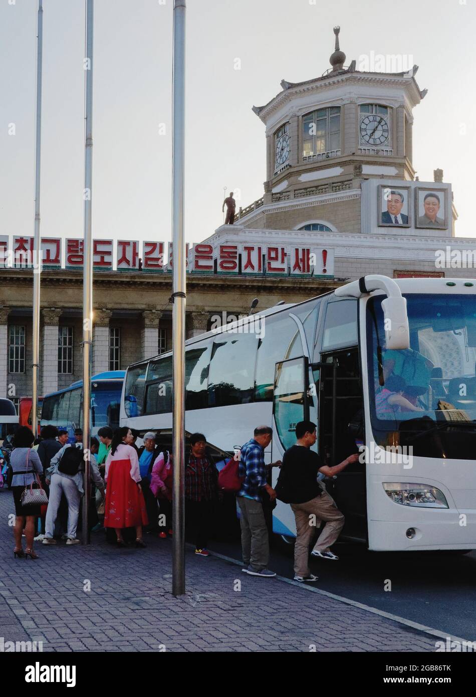 Tourists being guided onto a tour coach outside the railway station ...