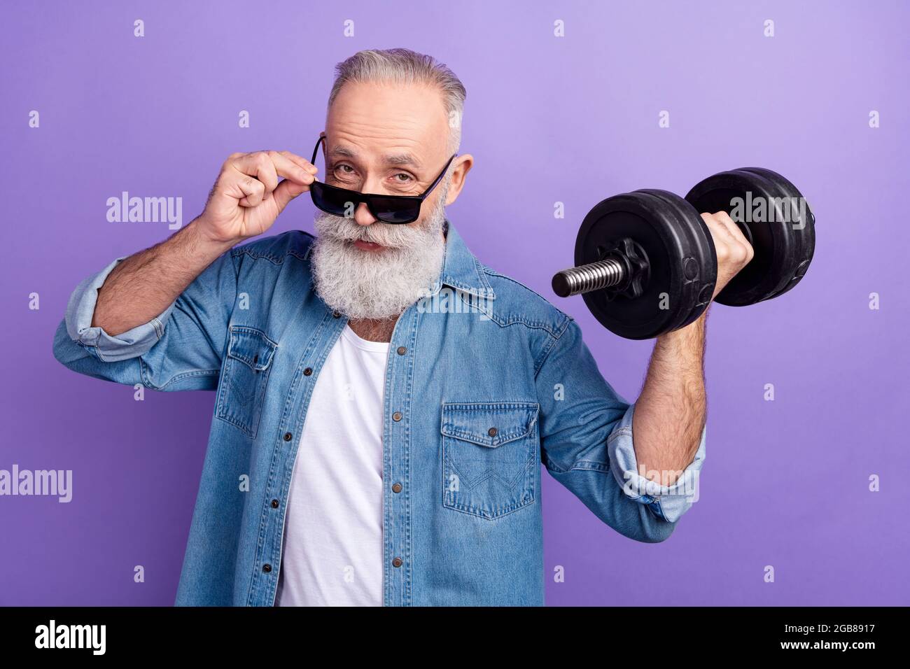 Photo of aged man sportive make exercises muscles biceps dumbells ...