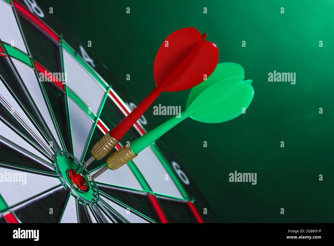 dart board with darts on green background Stock Photo - Alamy