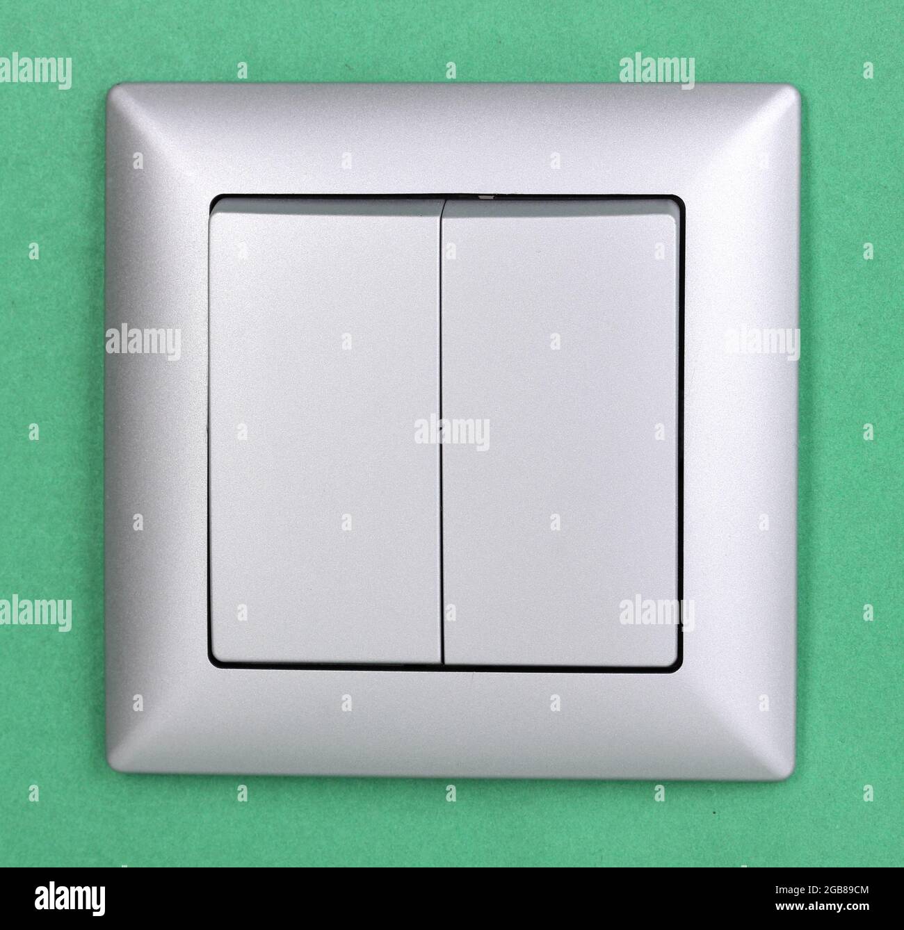 Modern light switch on green background Stock Photo - Alamy