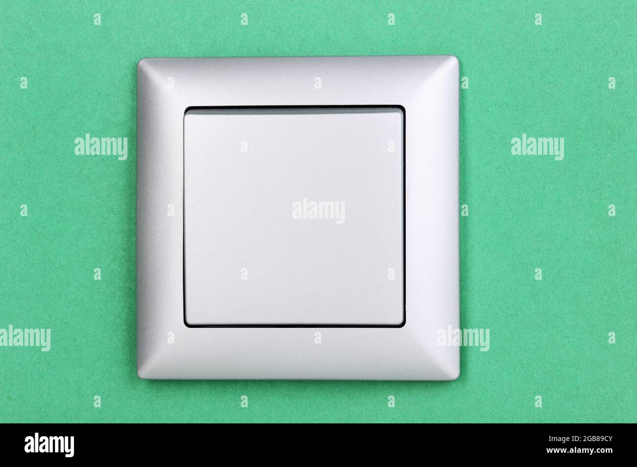 Modern light switch on green background Stock Photo - Alamy