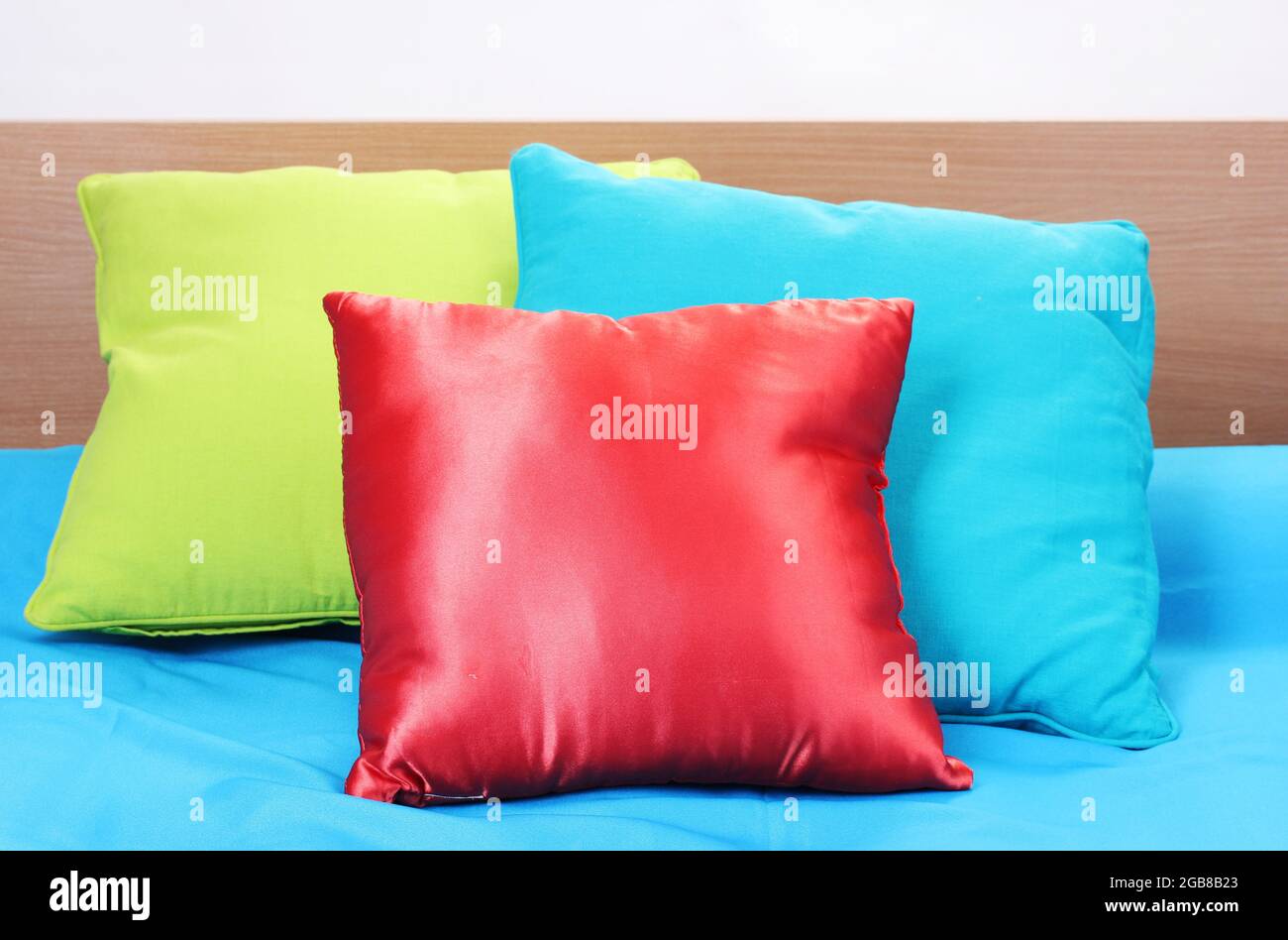 bright pillows on bed on white background Stock Photo - Alamy
