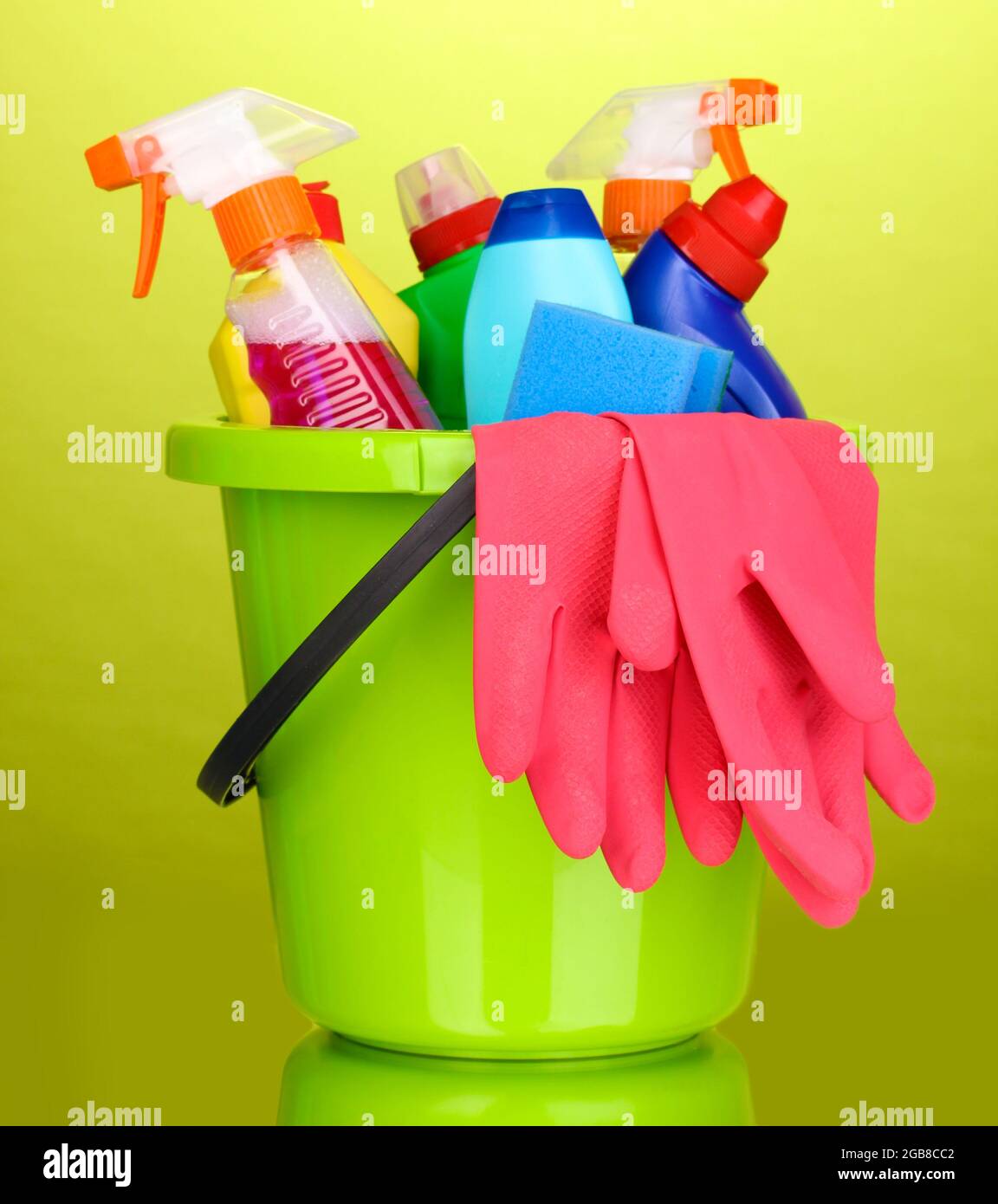Bucket with cleaning items on green background Stock Photo - Alamy