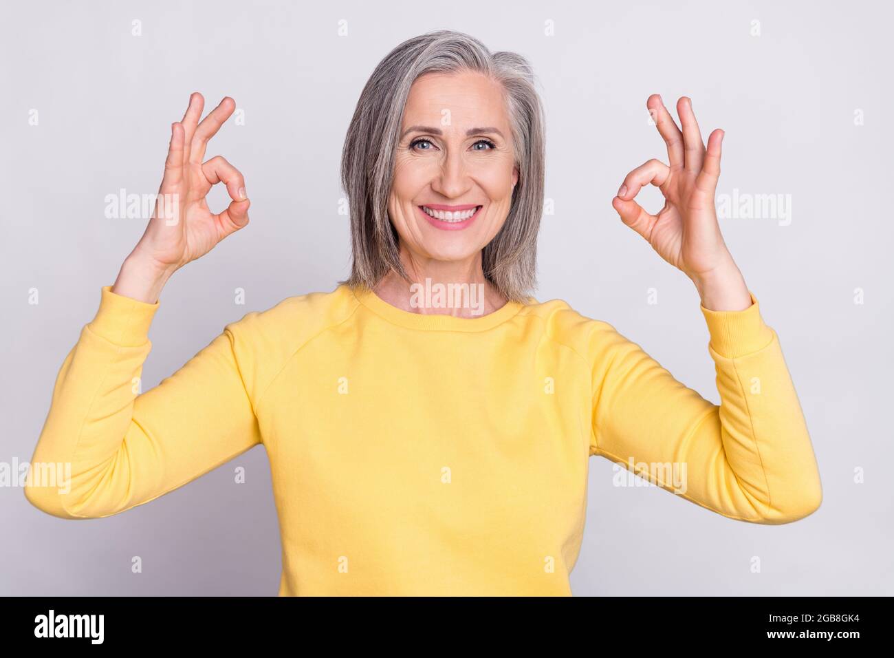 Photo of happy cheerful good mood mature woman showing okay sign wear ...