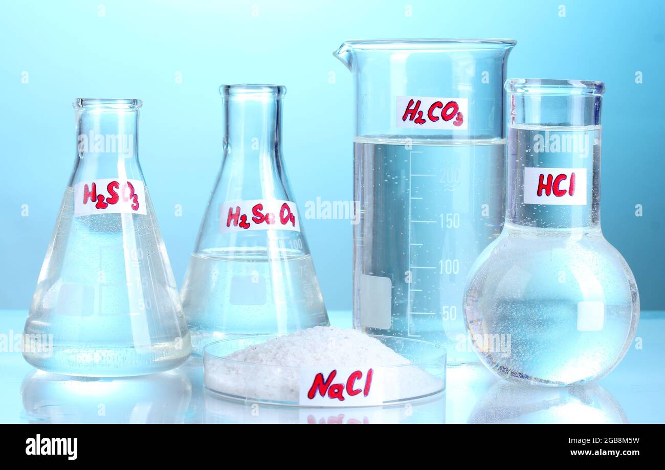 Test-tubes with various acids and chemicals on blue background Stock ...