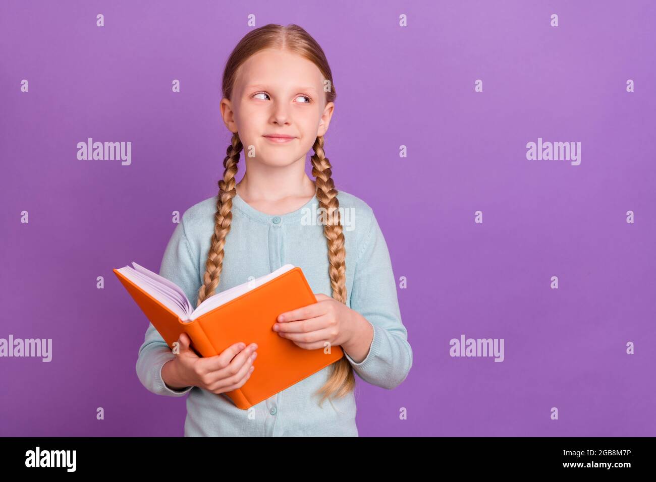 Photo of clever pensive girl hold read book look empty space memorize ...