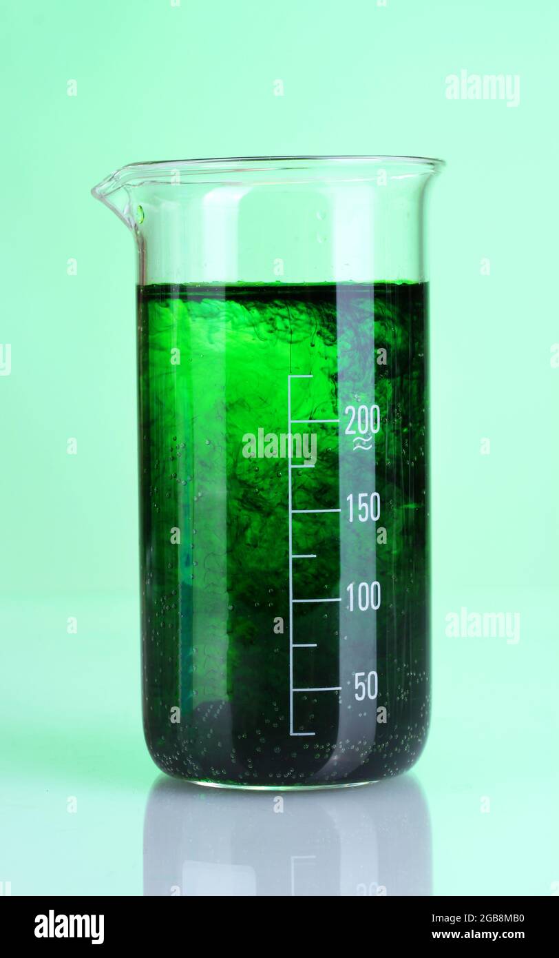 brightly ink in a flask with water on green background Stock Photo - Alamy