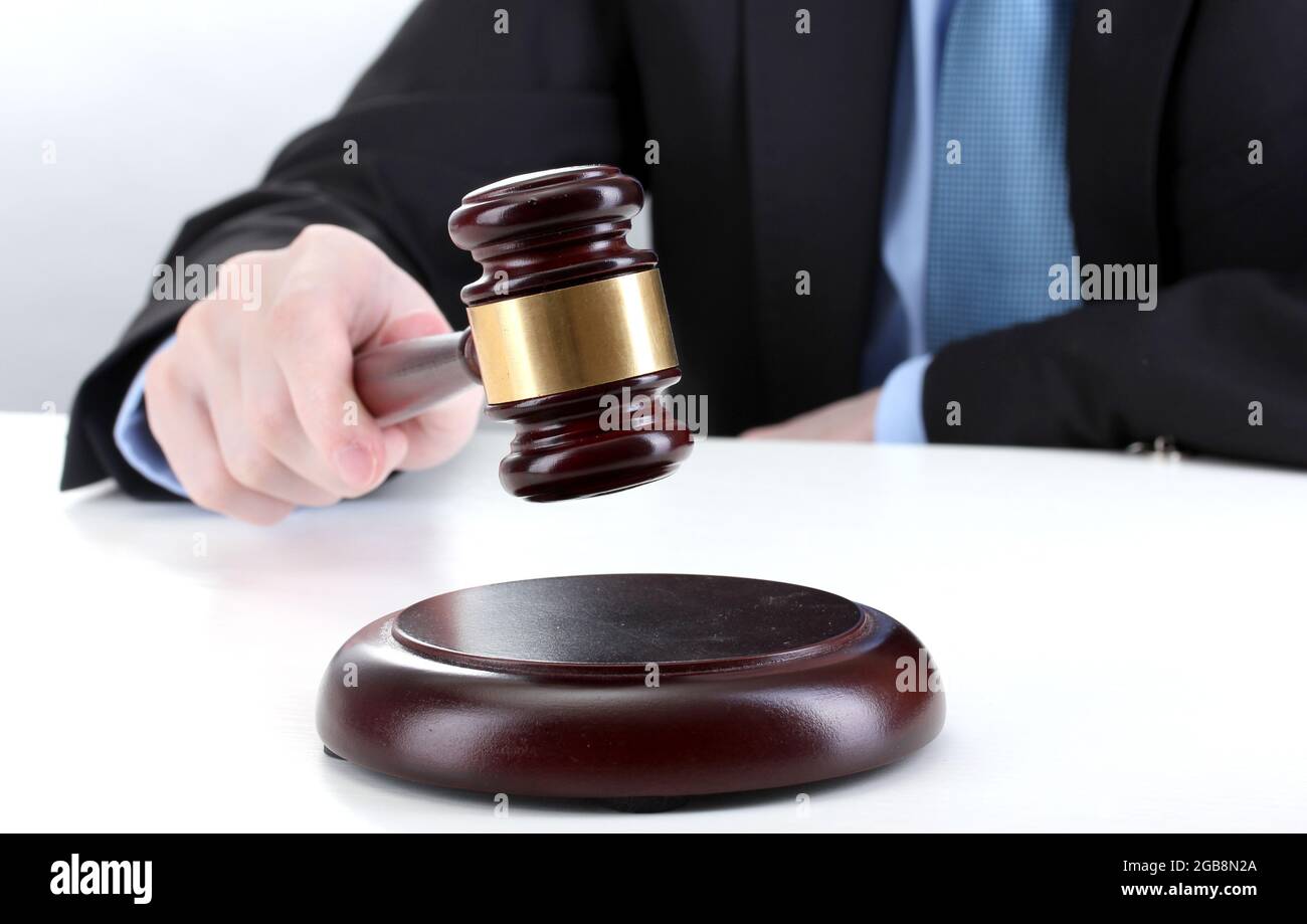 wooden gavel in hand on gray background Stock Photo - Alamy