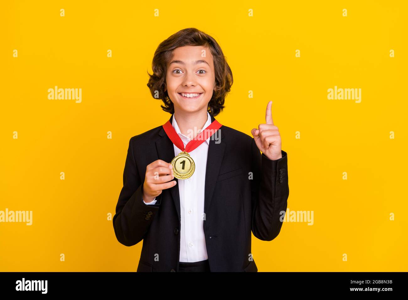 Photo of genius winner boy showing first place medal raise finger wear ...