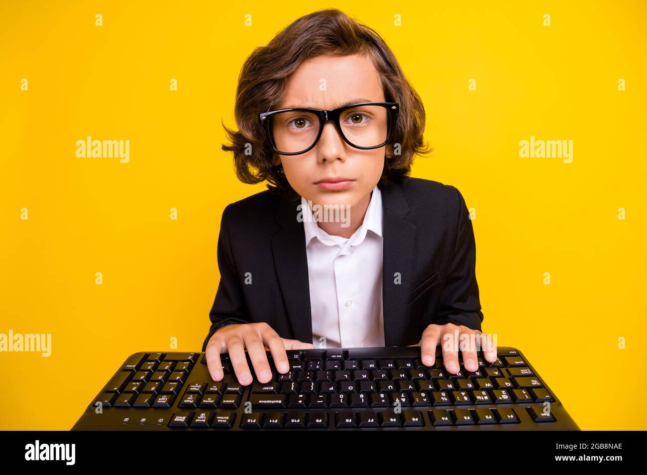 Photo of calm learner boy typing keyboard look web camera wear glasses ...