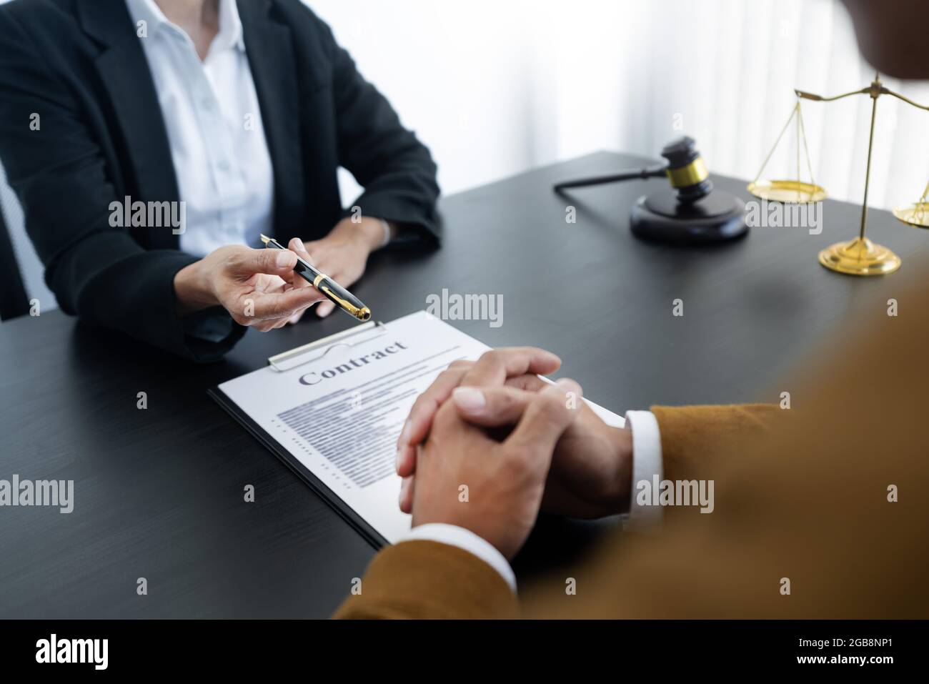 law,libra scale and hammer on the table, 2 lawyers are discussing about ...