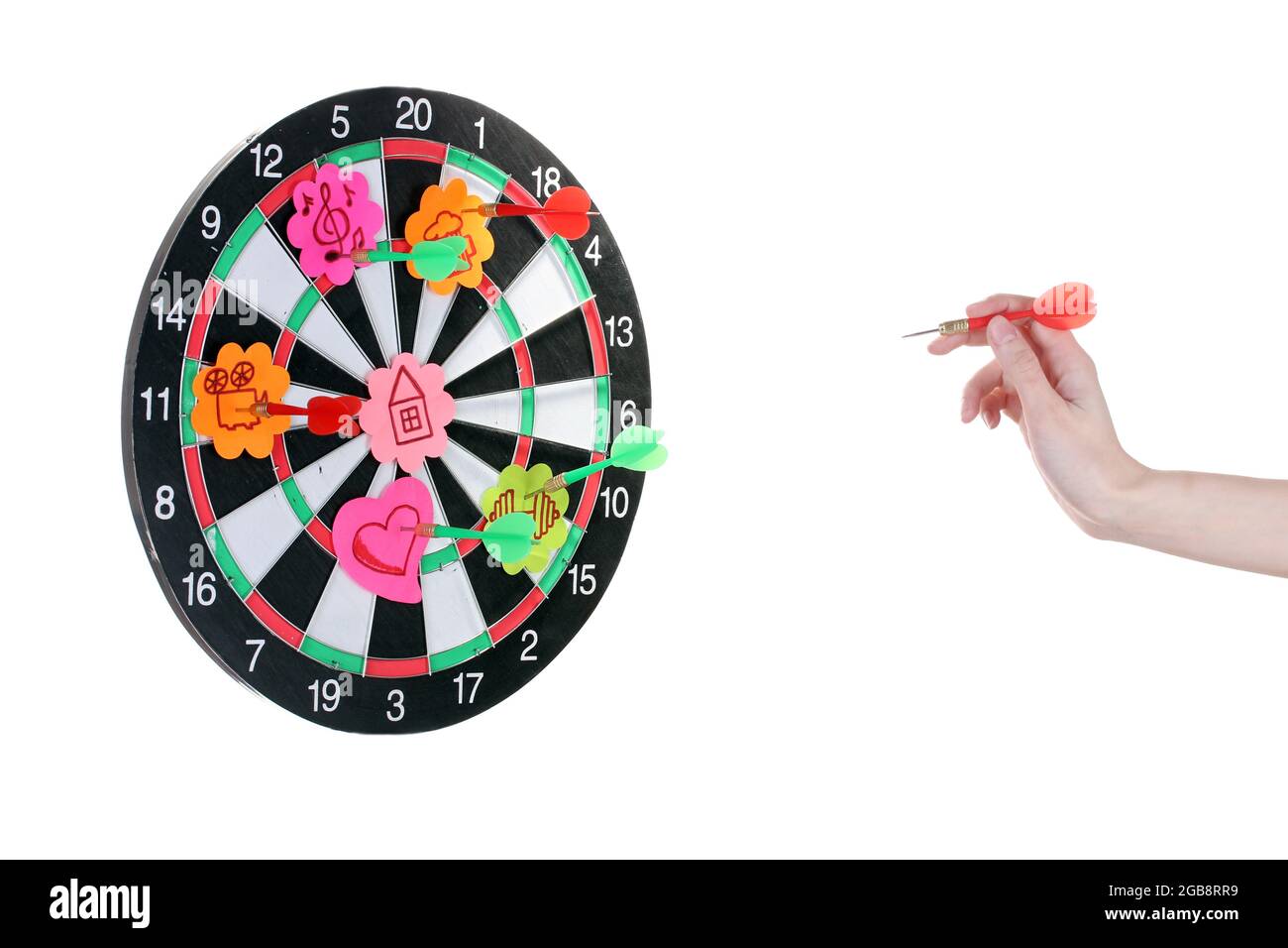 A hand throwing a dart at a sticker on darts on white background Stock ...