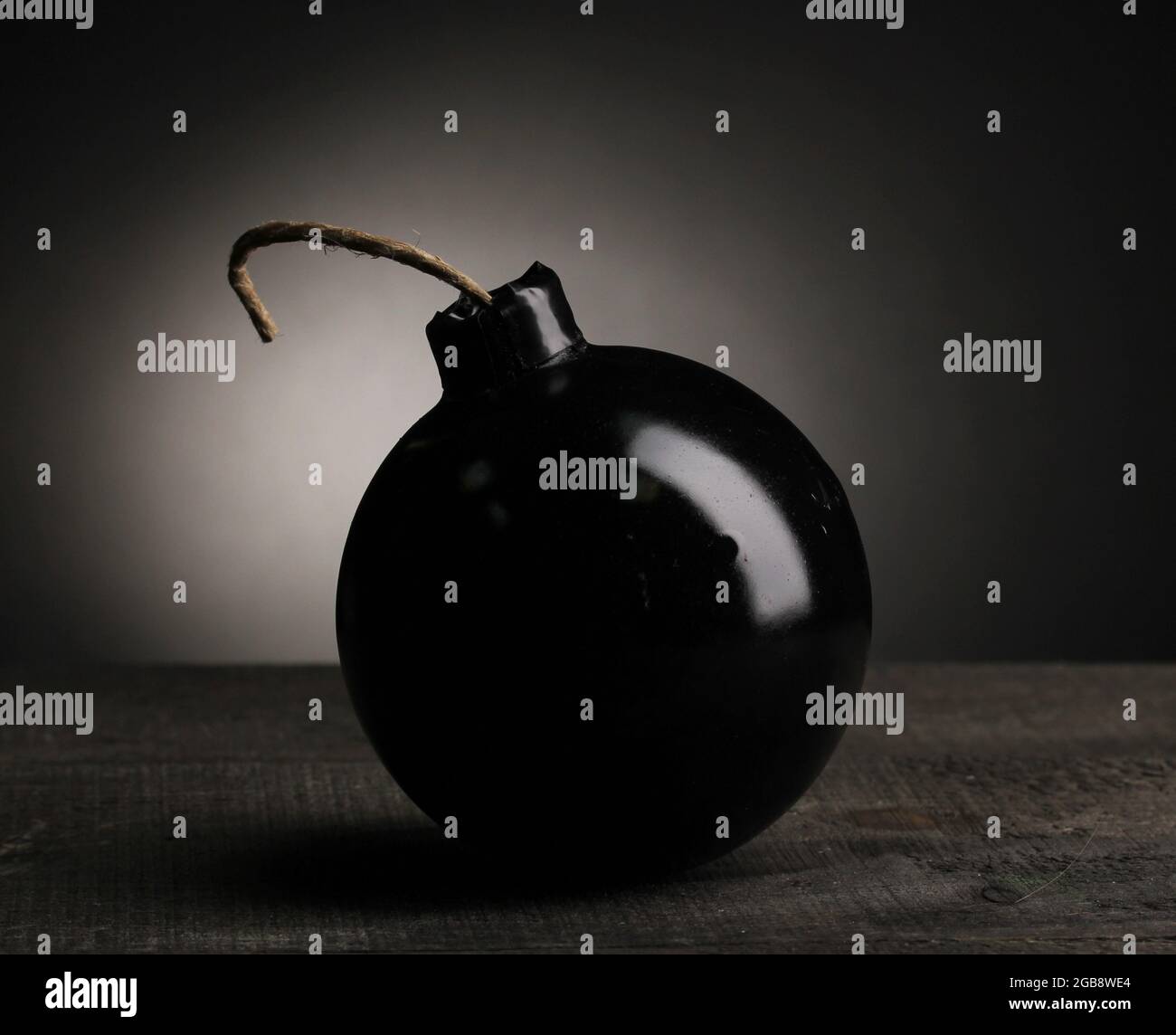 Cartoon style bomb on wooden table on black background Stock Photo - Alamy